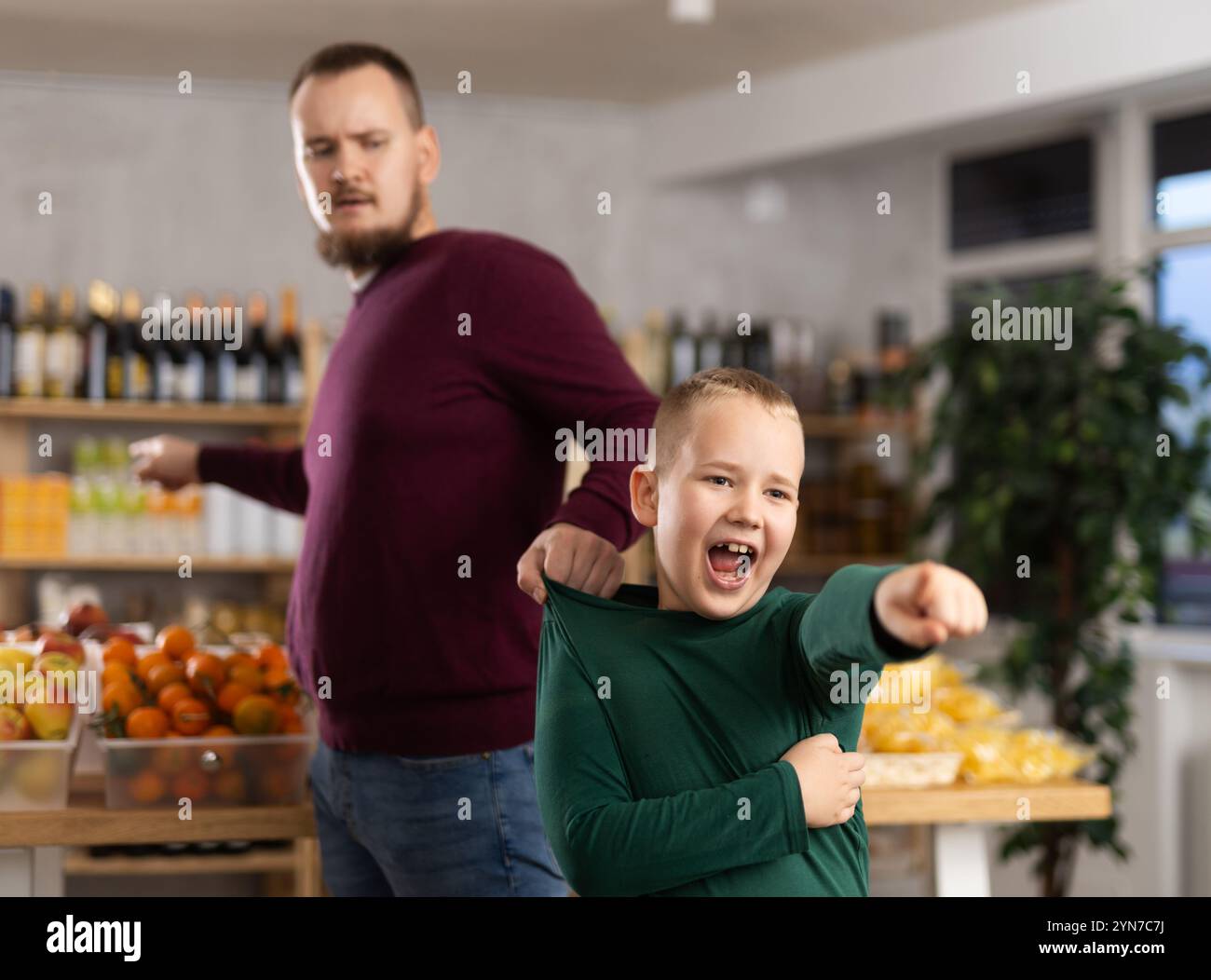 Angry dad dragging his little son behaving capricious in market Stock ...