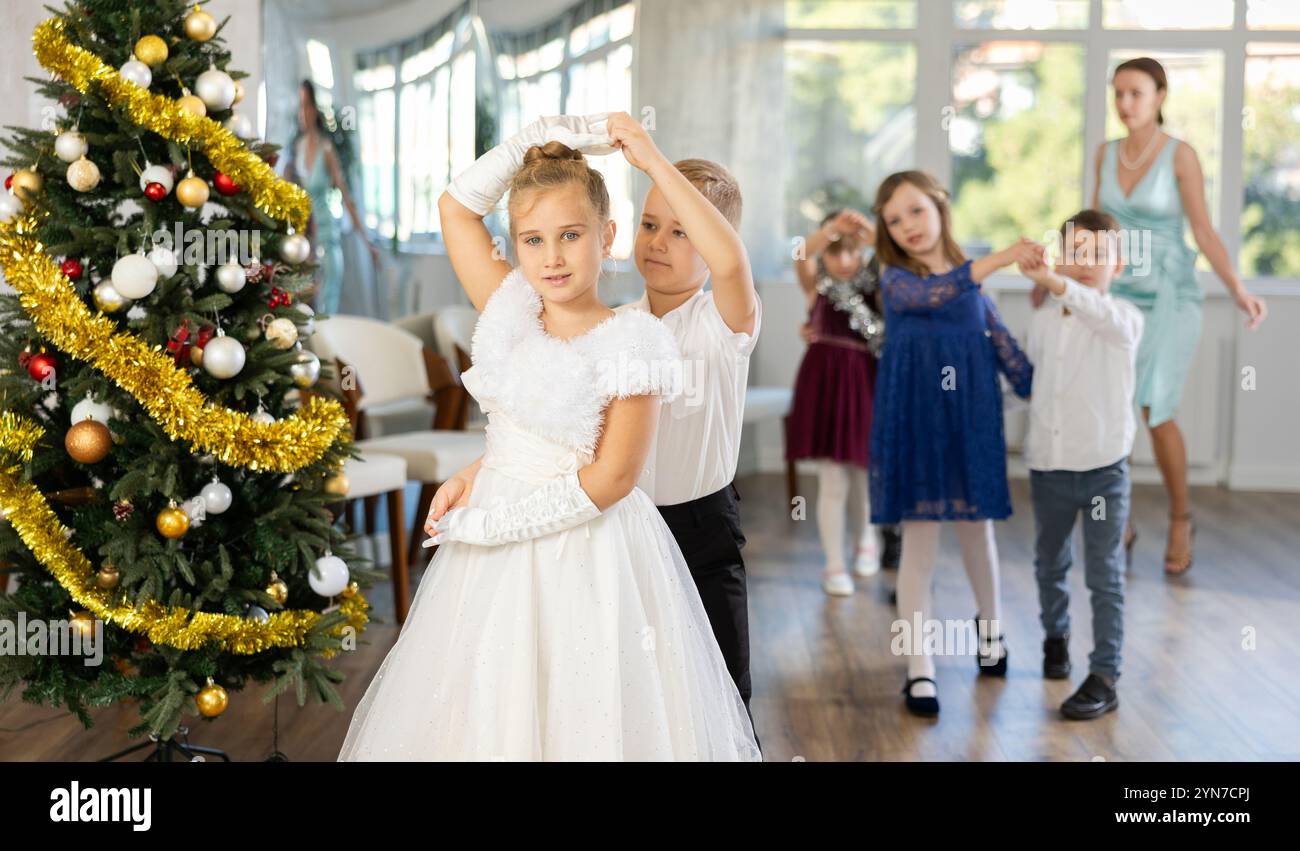 Little children practicing waltz dance in school-hall decorated with ...