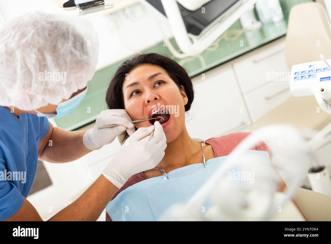 Dentist examining asian female patient teeth Stock Photo - Alamy