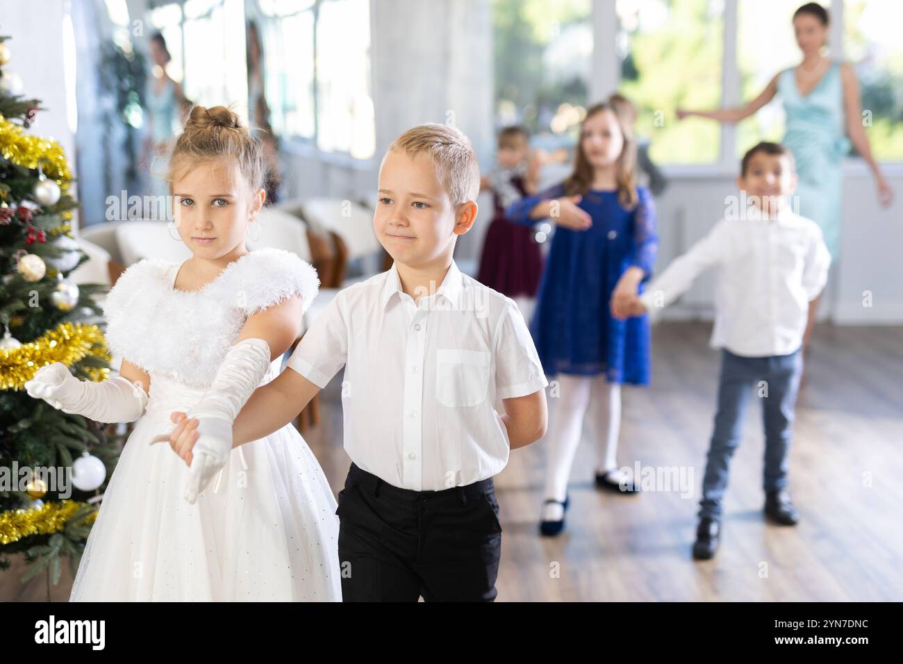 Christmas ball - group of children in festive clothes dances a waltz ...