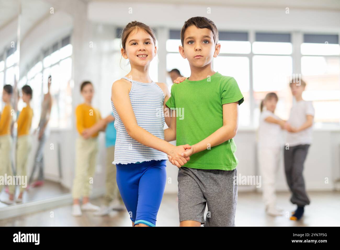 Happy preteen children practicing ballroom dances in pairs in training ...