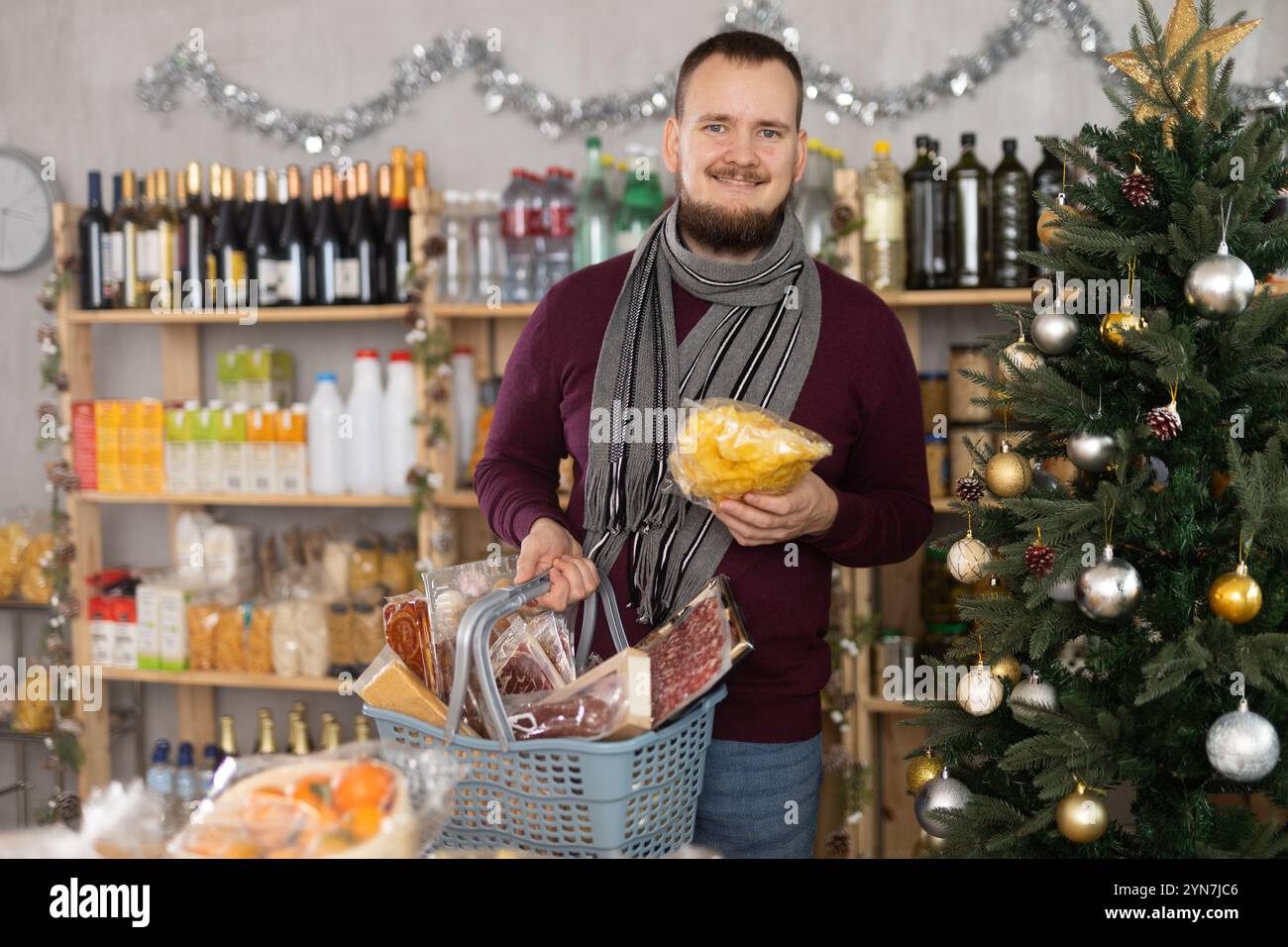 Young man choosing chips in grocery store Stock Photo - Alamy