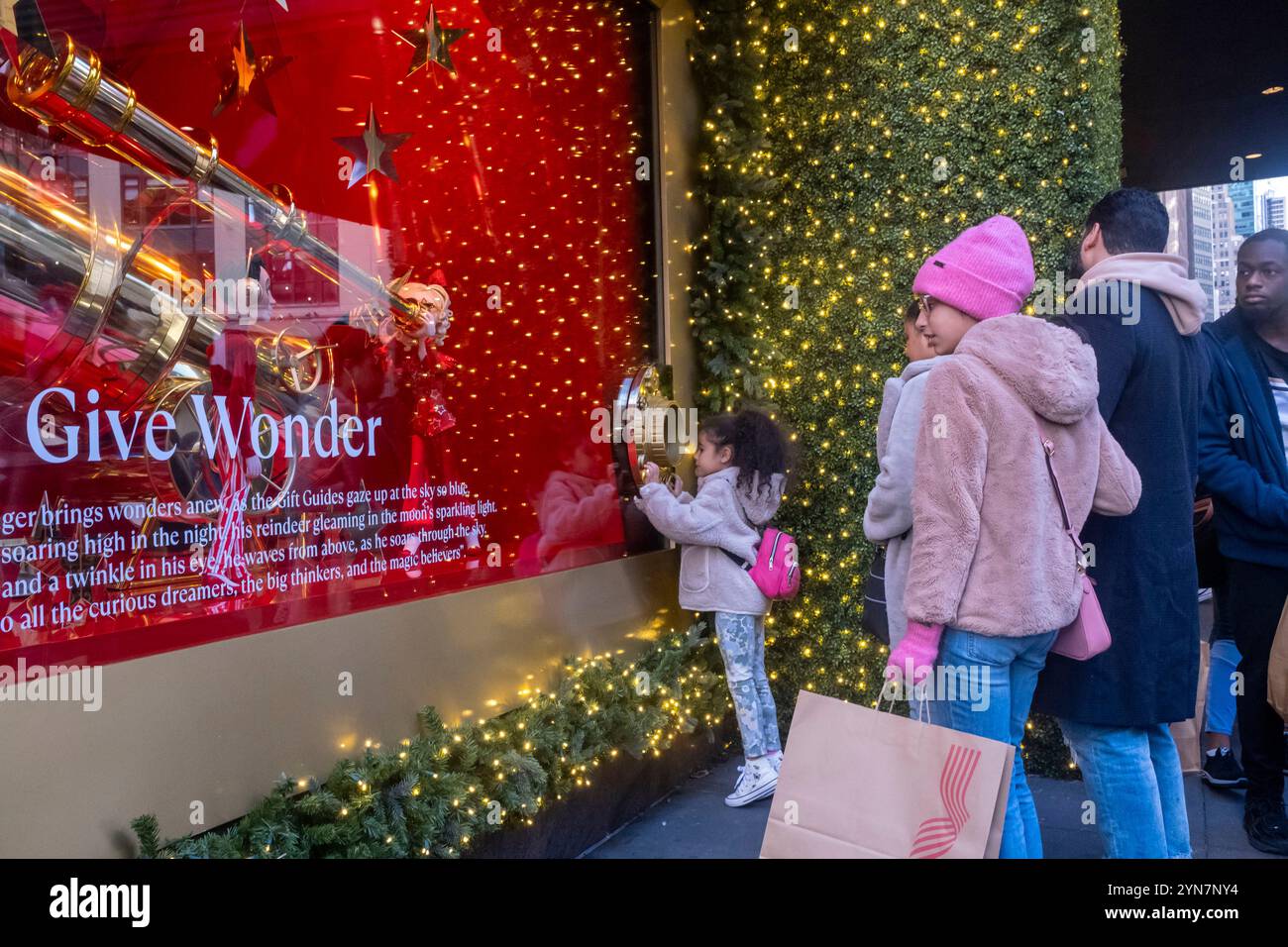 NEW YORK, NEW YORK - NOVEMBER 24: People look at Macy's holiday window ...