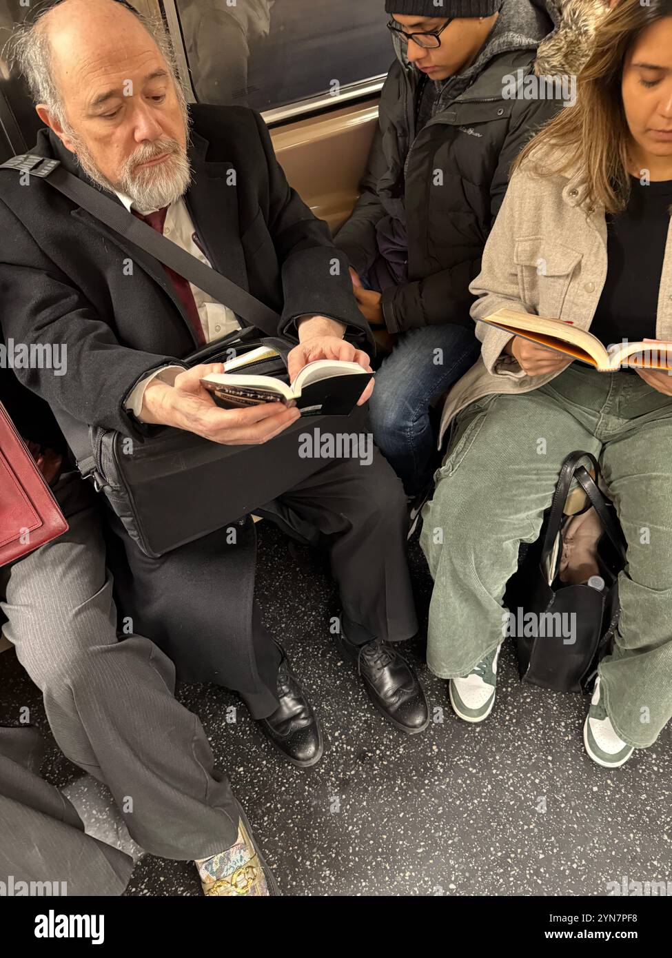 People reading books as they ride a New York City subway train in New ...