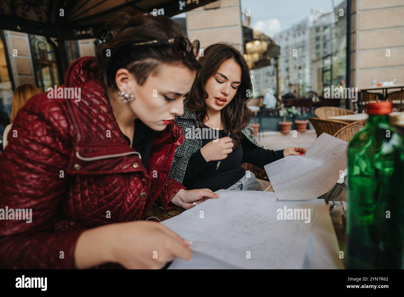 Focused business meeting outdoors with two people reviewing documents ...
