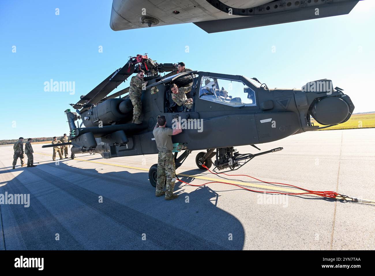 U.S. Army personnel prepare to load A Boeing AH-64 Apache helicopter into a U.S. Air Force C-17 ...