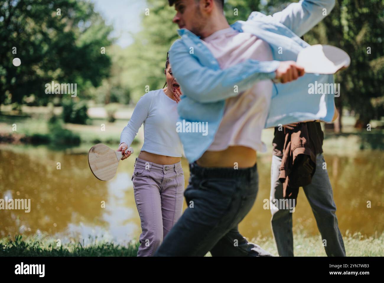Young friends enjoying a lively game of paddle ball outdoors Stock ...