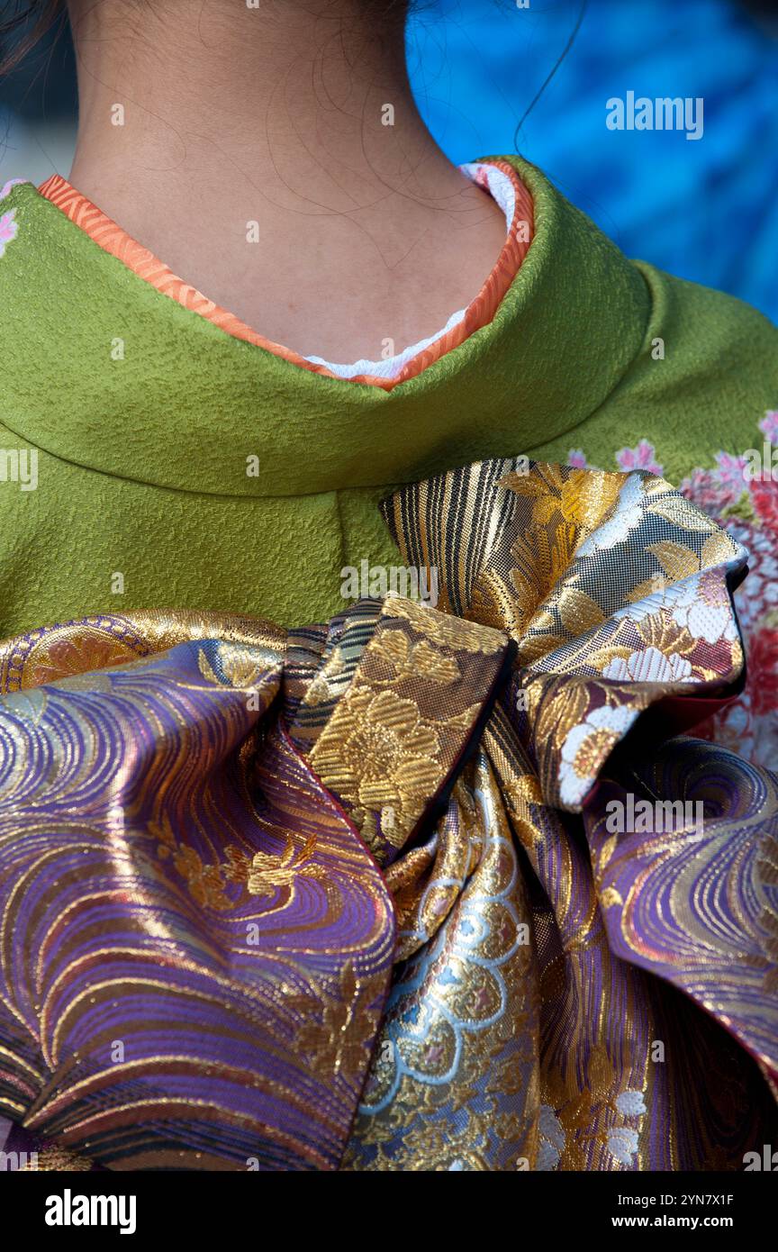 Colorful silk obi (kimono sash) tied behind the back of a woman wearing ...