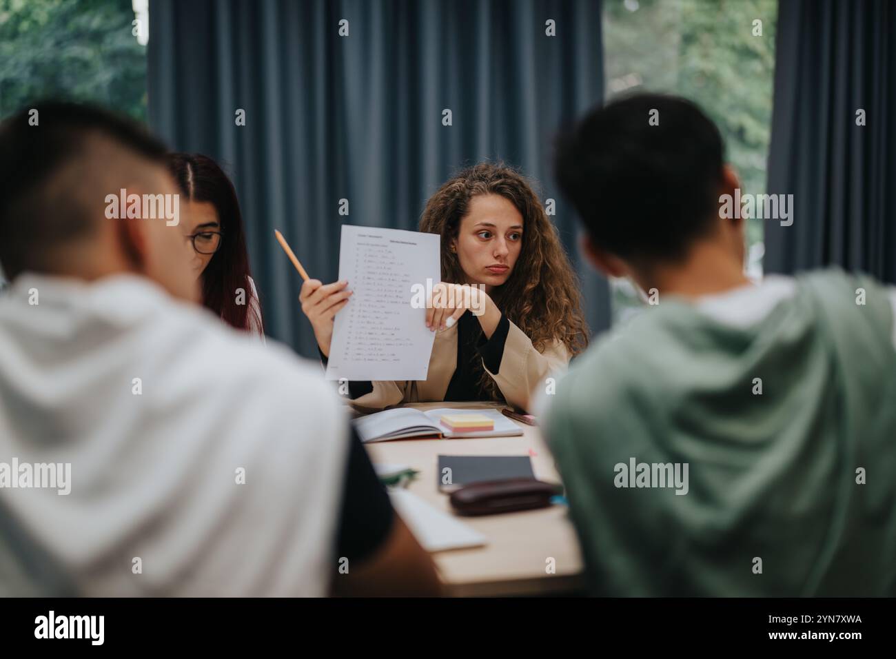 Group of students discussing academic topics in a classroom setting ...