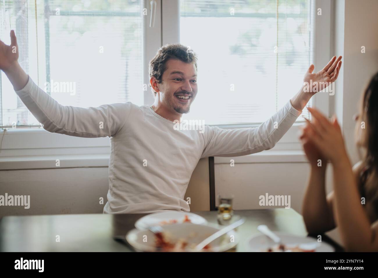 Joyful man laughing and socializing at dining table Stock Photo - Alamy