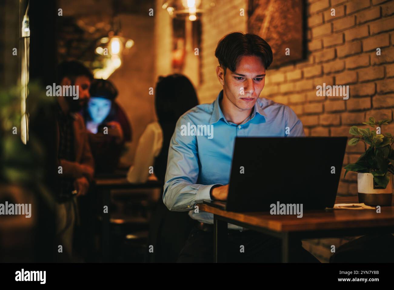 Business person working late at night in cozy coffee bar Stock Photo ...