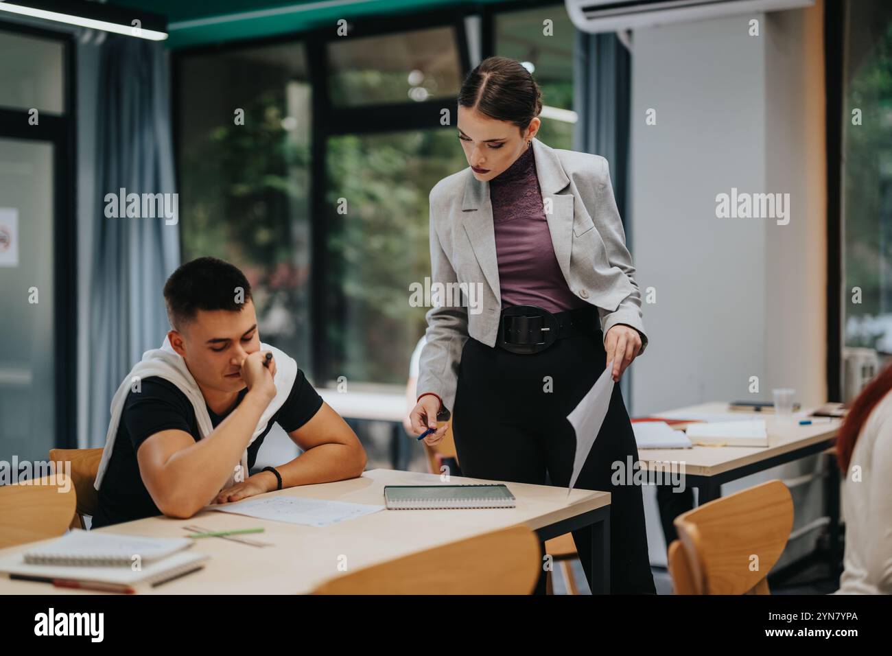 Teacher assisting student in modern classroom environment Stock Photo - Alamy