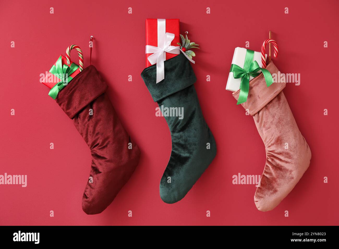 Christmas socks with gifts, candy canes and mistletoe twigs hanging on ...