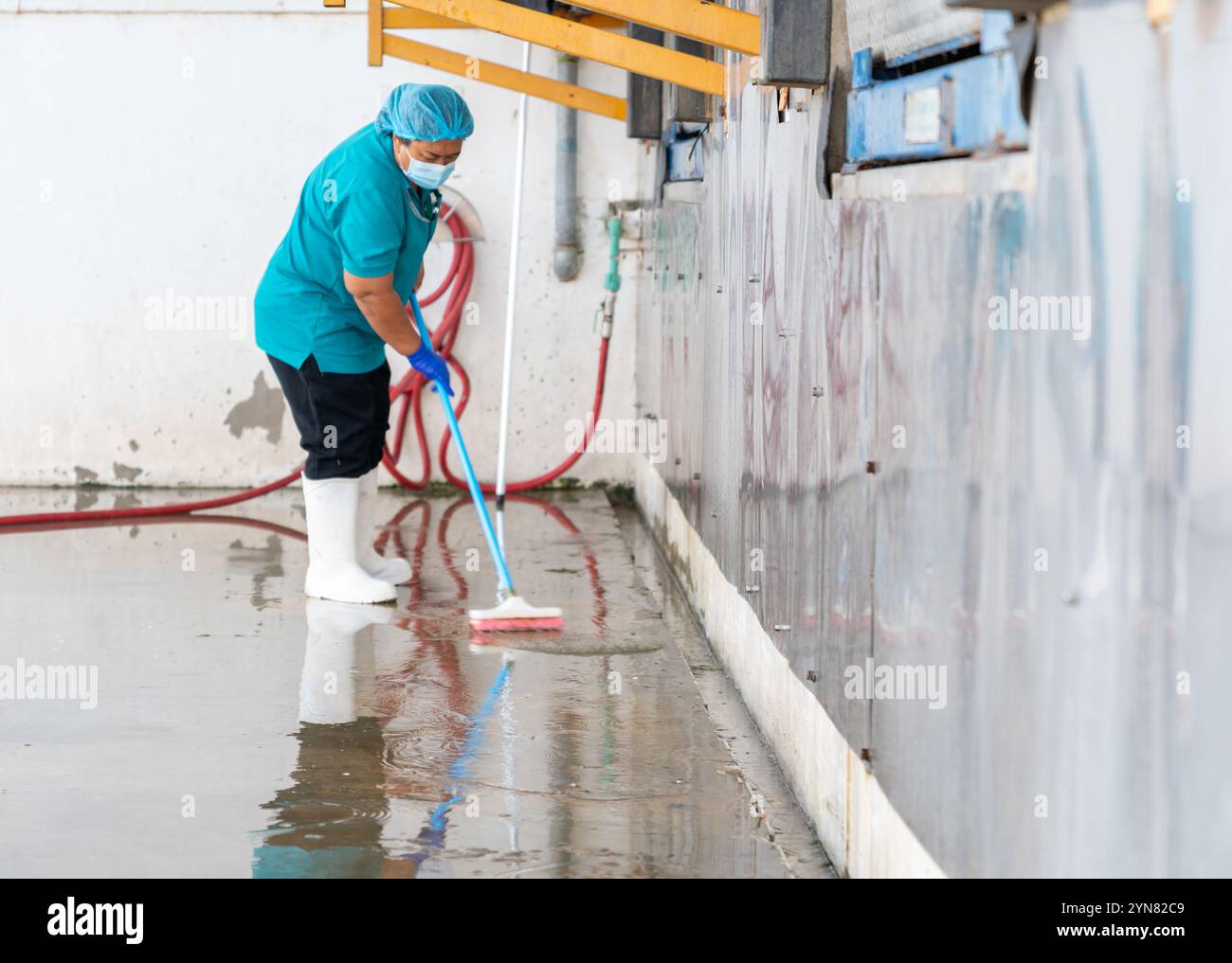 Female staff cleaning the floor withe mob in factory Stock Photo - Alamy