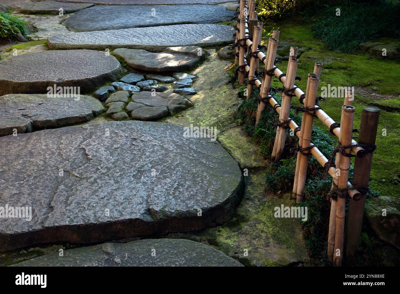 Japanese garden detail of a flat steppingstone pathway bordered by a ...