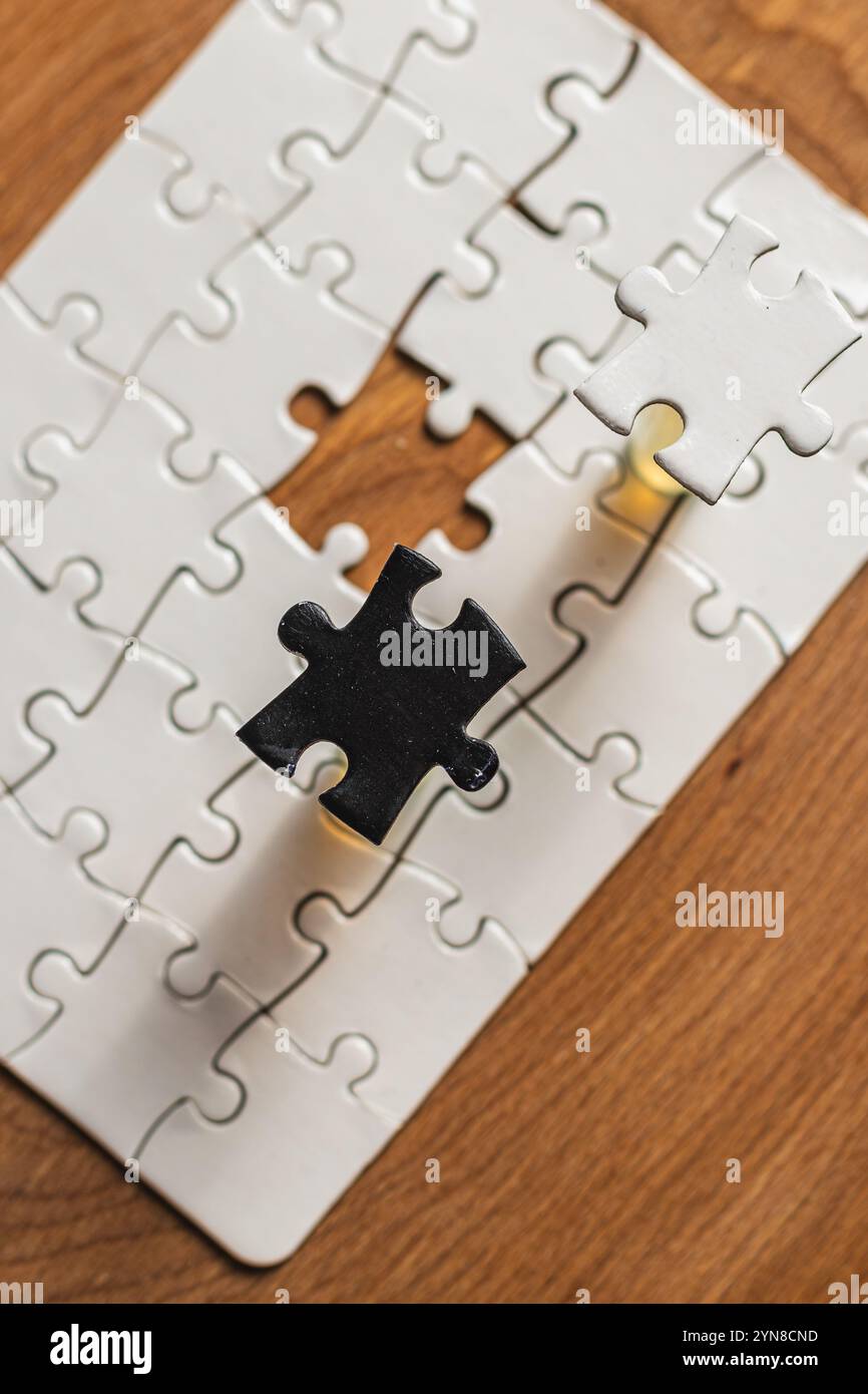 Opposite day concept using white and black puzzle pieces on a white ...