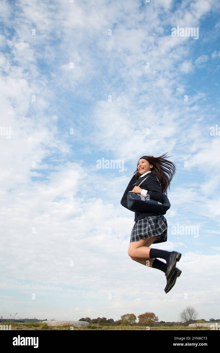 High school girl in school uniform jumping Stock Photo - Alamy