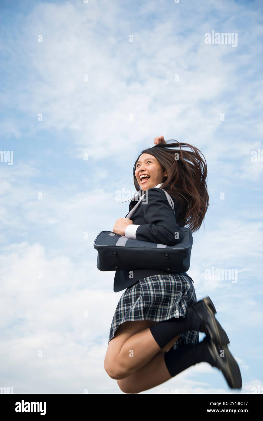 High school girl in school uniform jumping Stock Photo - Alamy