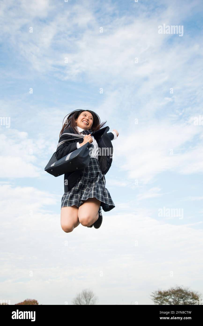 High school girl in school uniform jumping Stock Photo - Alamy