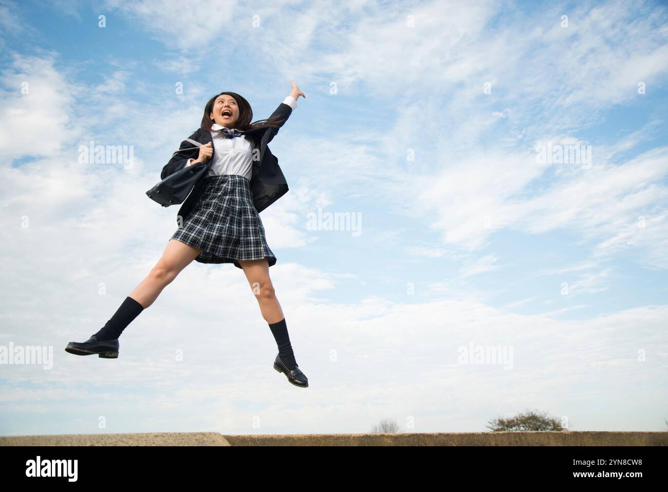 High school girl in school uniform jumping Stock Photo - Alamy
