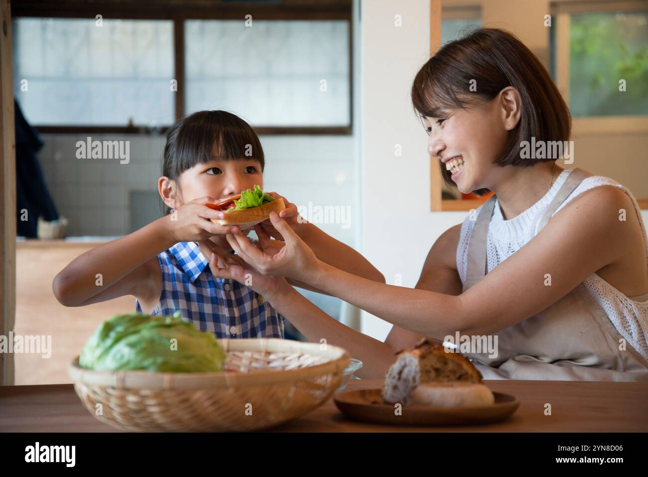 Girl and mother eating sandwich Stock Photo - Alamy