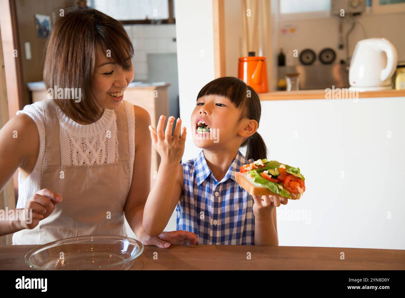 Girl and mother eating sandwich Stock Photo - Alamy