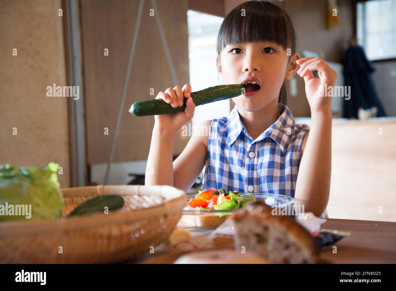 Girl nibbling on cucumber Stock Photo - Alamy
