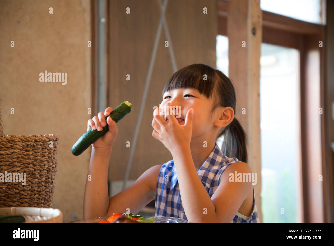 Girl eating cucumber Stock Photo - Alamy