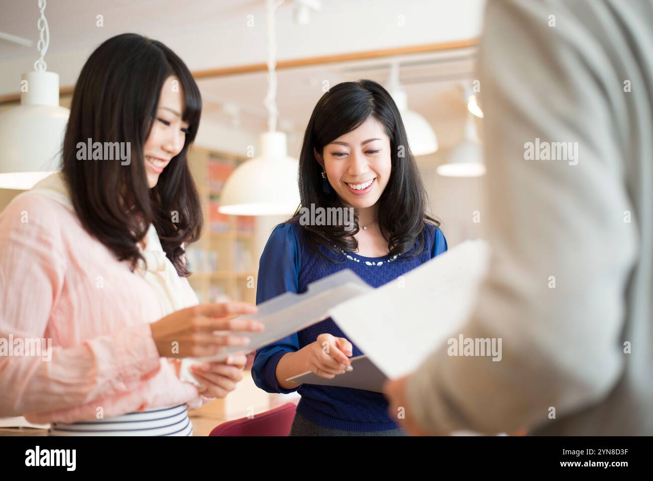 Three people in a meeting standing up Stock Photo - Alamy