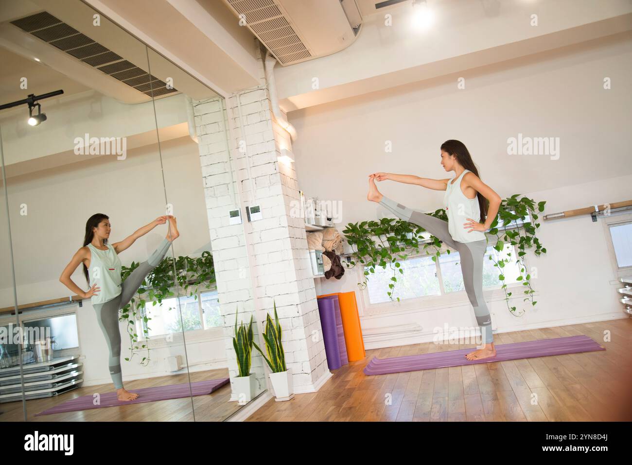 Female yoga instructor doing a pose in studio Stock Photo - Alamy