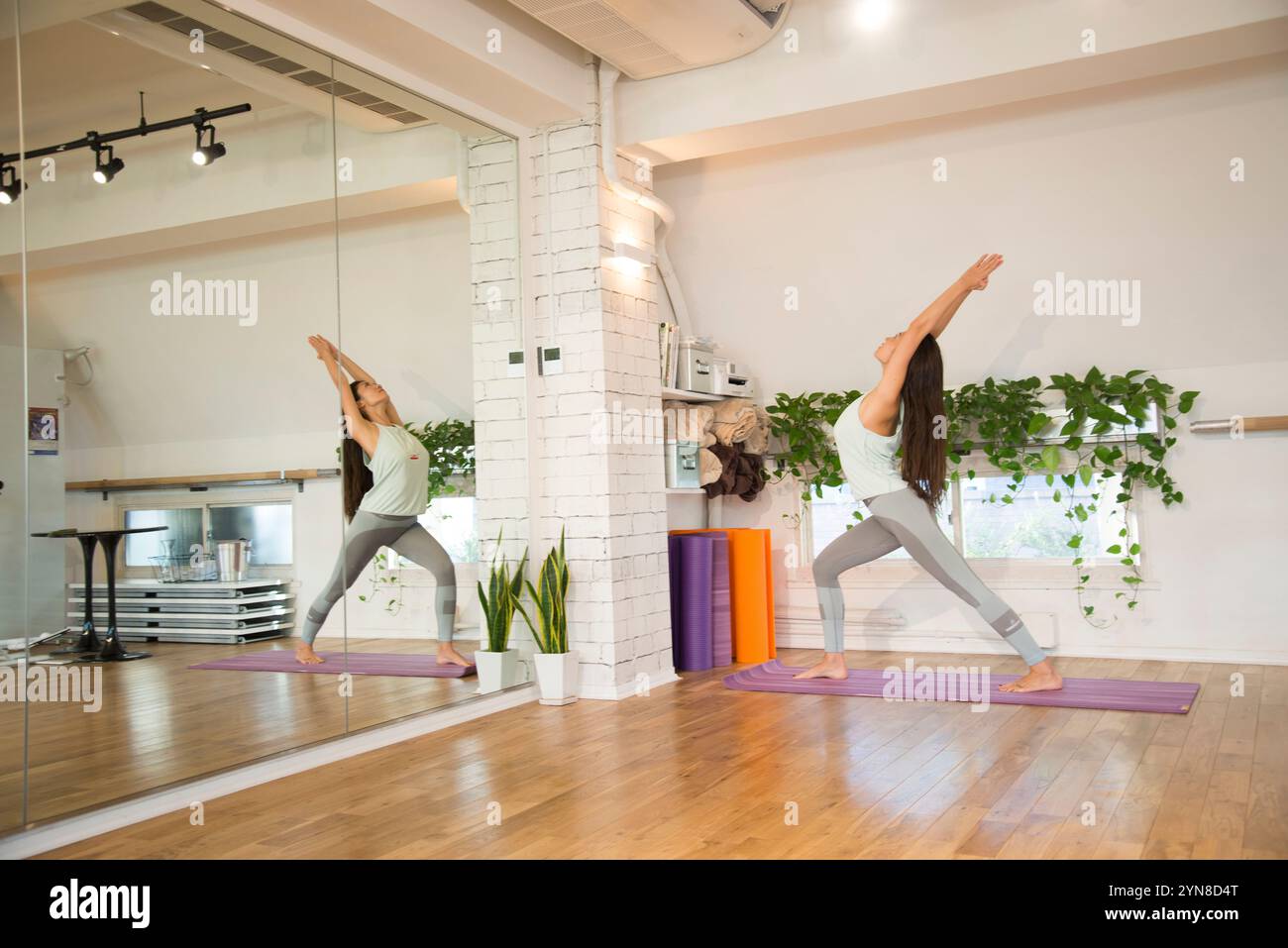 Female yoga instructor doing a pose in studio Stock Photo - Alamy