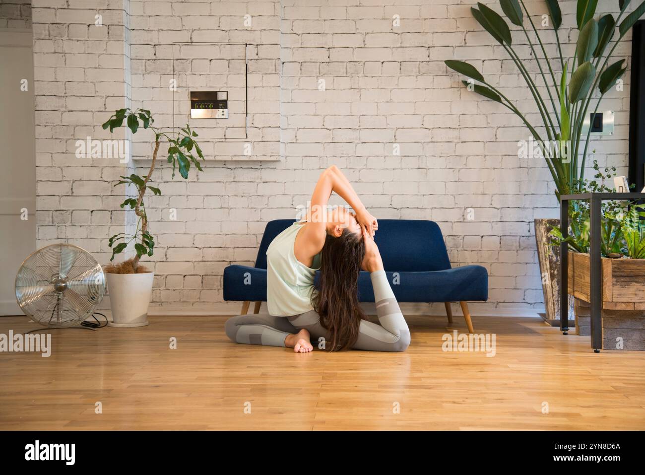 Female yoga instructor doing a pose on the floor Stock Photo - Alamy