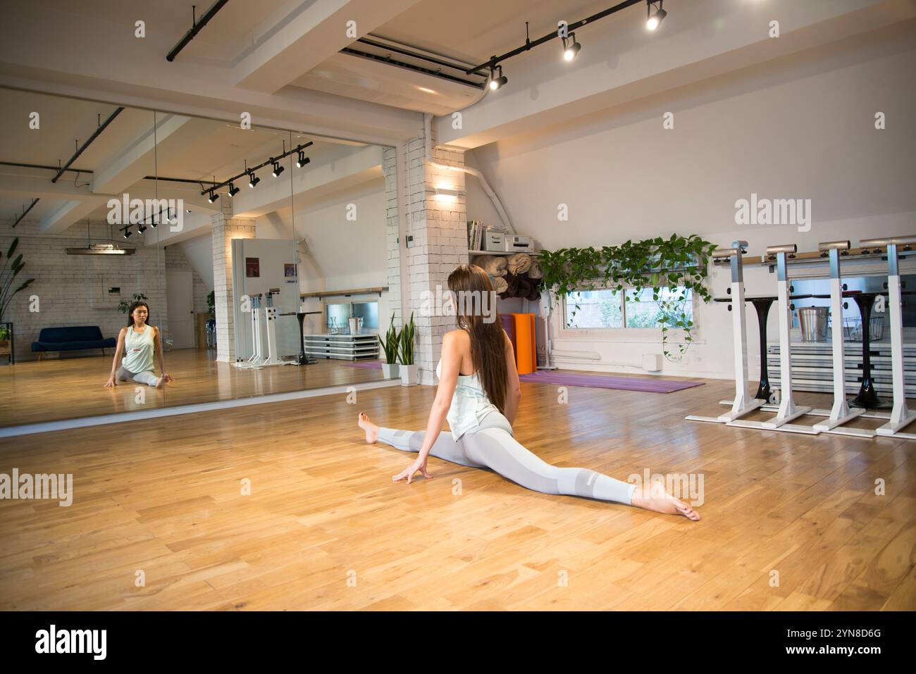 Female yoga instructor doing a pose in studio Stock Photo - Alamy
