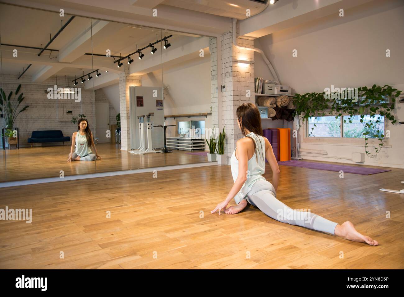 Female yoga instructor doing a pose in studio Stock Photo - Alamy