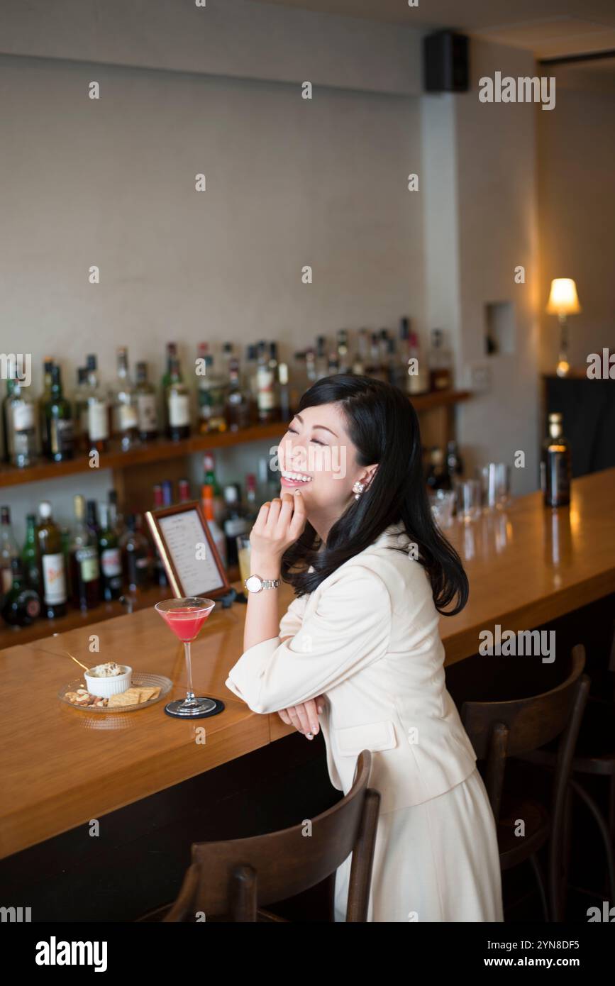 Woman at a bar alone Stock Photo - Alamy