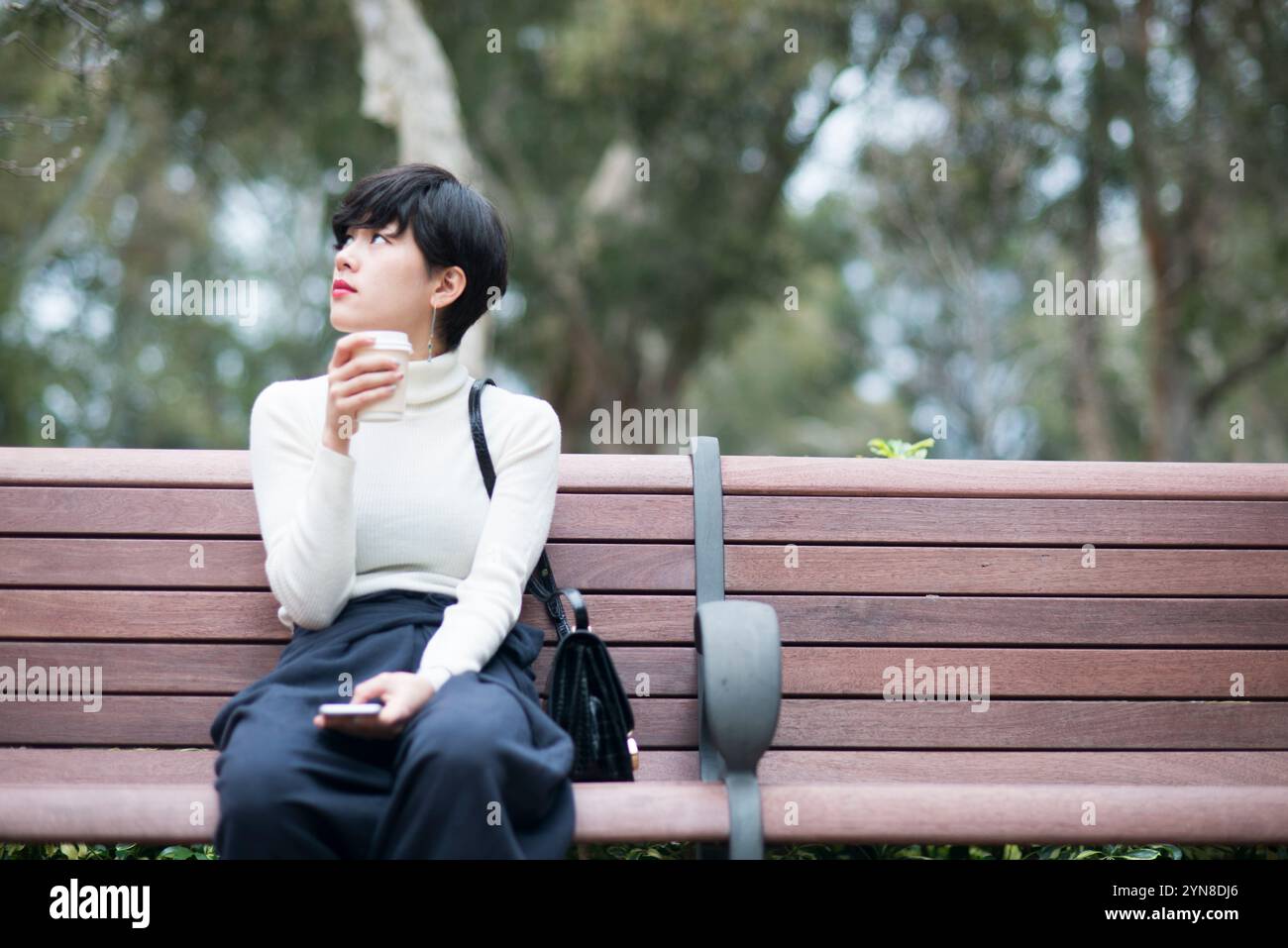 Woman sitting on bench Stock Photo - Alamy