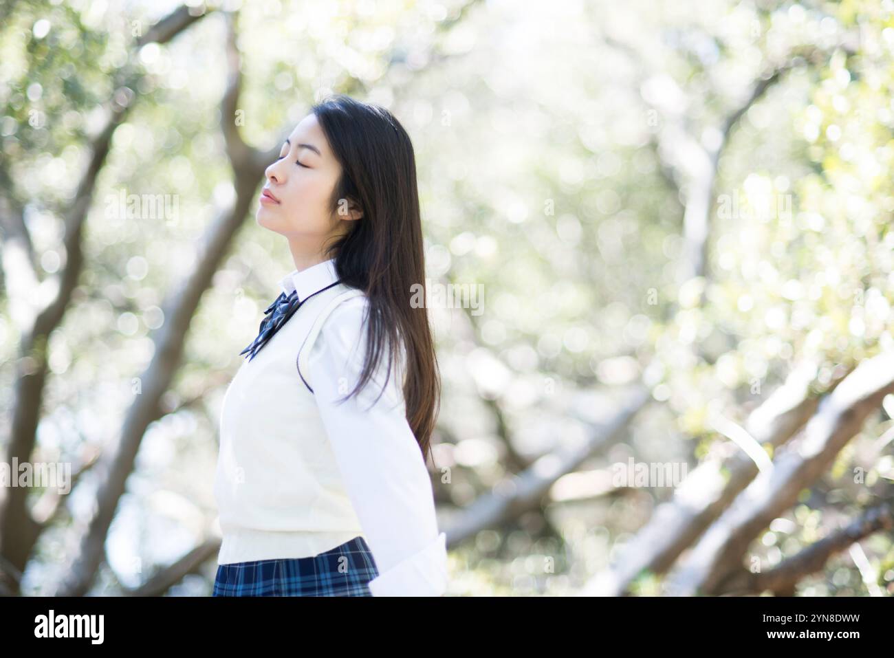 Schoolgirl in school uniform taking a deep breath in the forest Stock ...