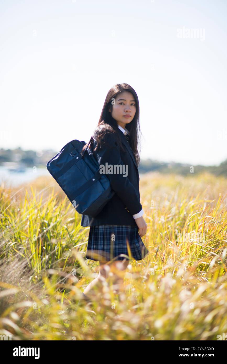 High school girl in uniform standing on grassland Stock Photo - Alamy