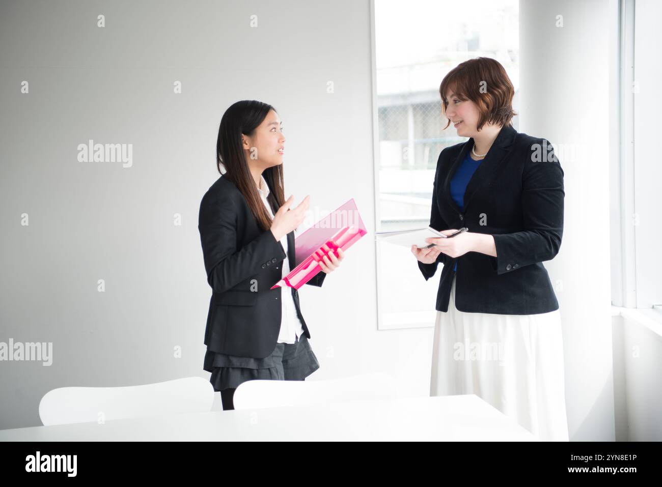 Two women talking in conference room Stock Photo - Alamy