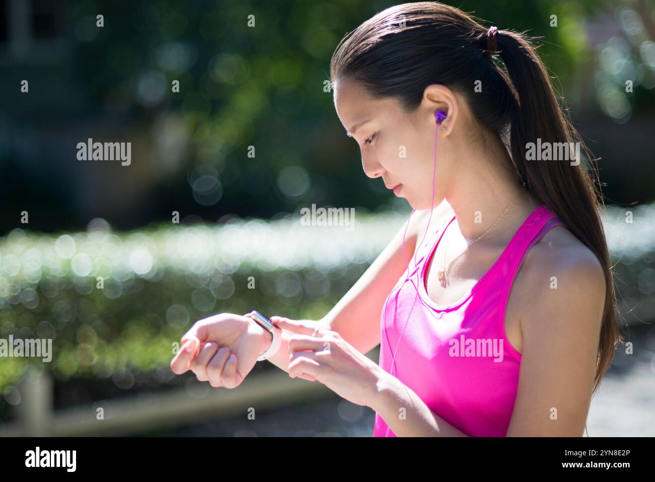 Woman checking exercise information on a clock Stock Photo - Alamy