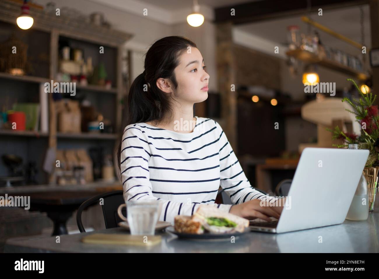 Woman opening a computer in a café Stock Photo - Alamy
