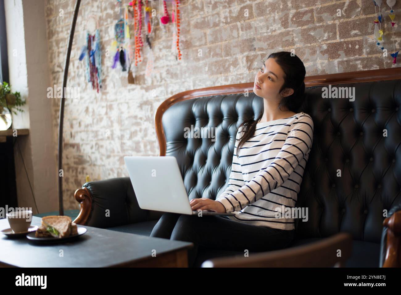 Woman opening a computer in a café Stock Photo - Alamy