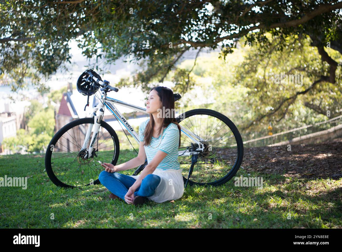 Woman resting in front of bicycle Stock Photo - Alamy