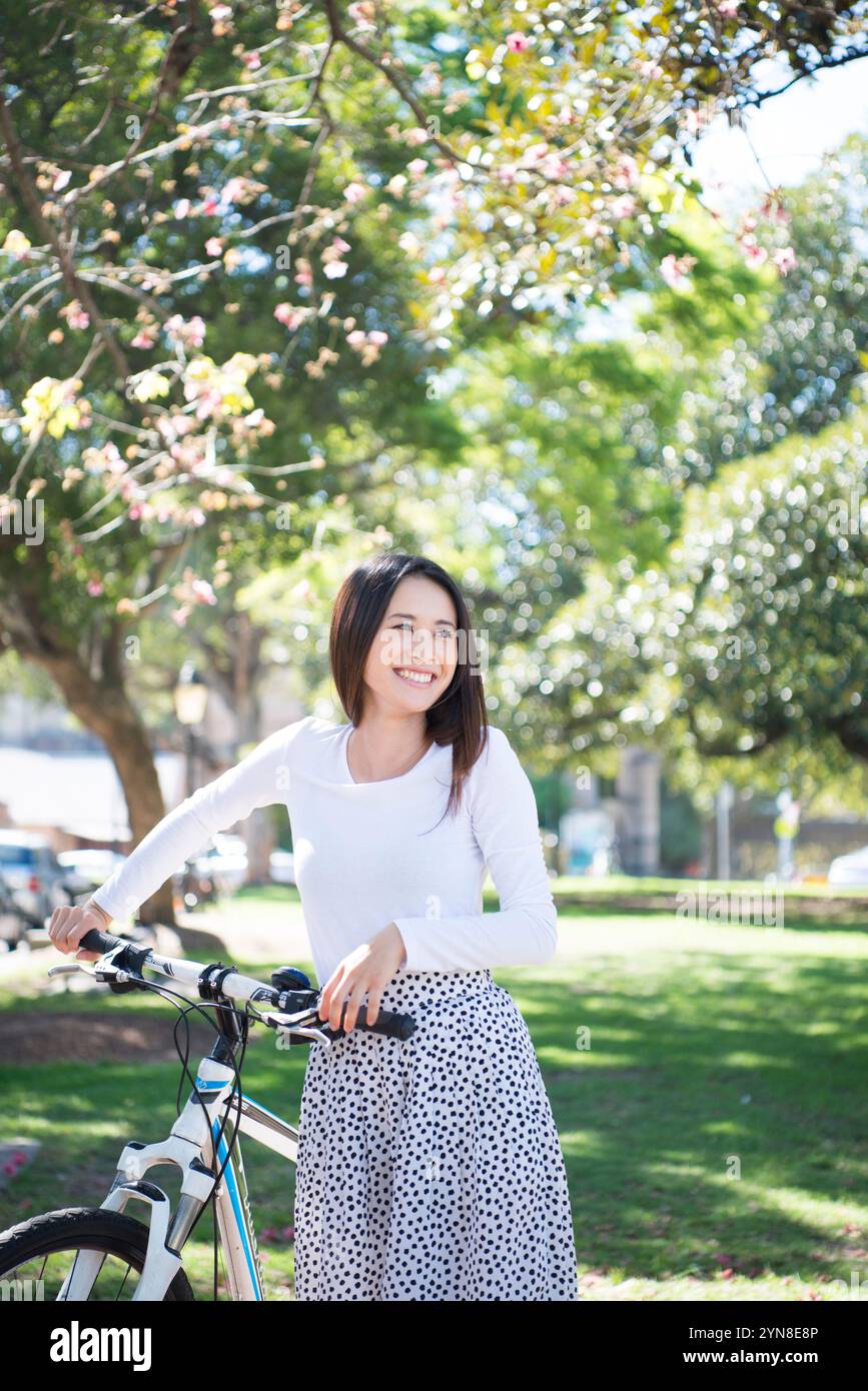 Woman pulling a bicycle Stock Photo - Alamy
