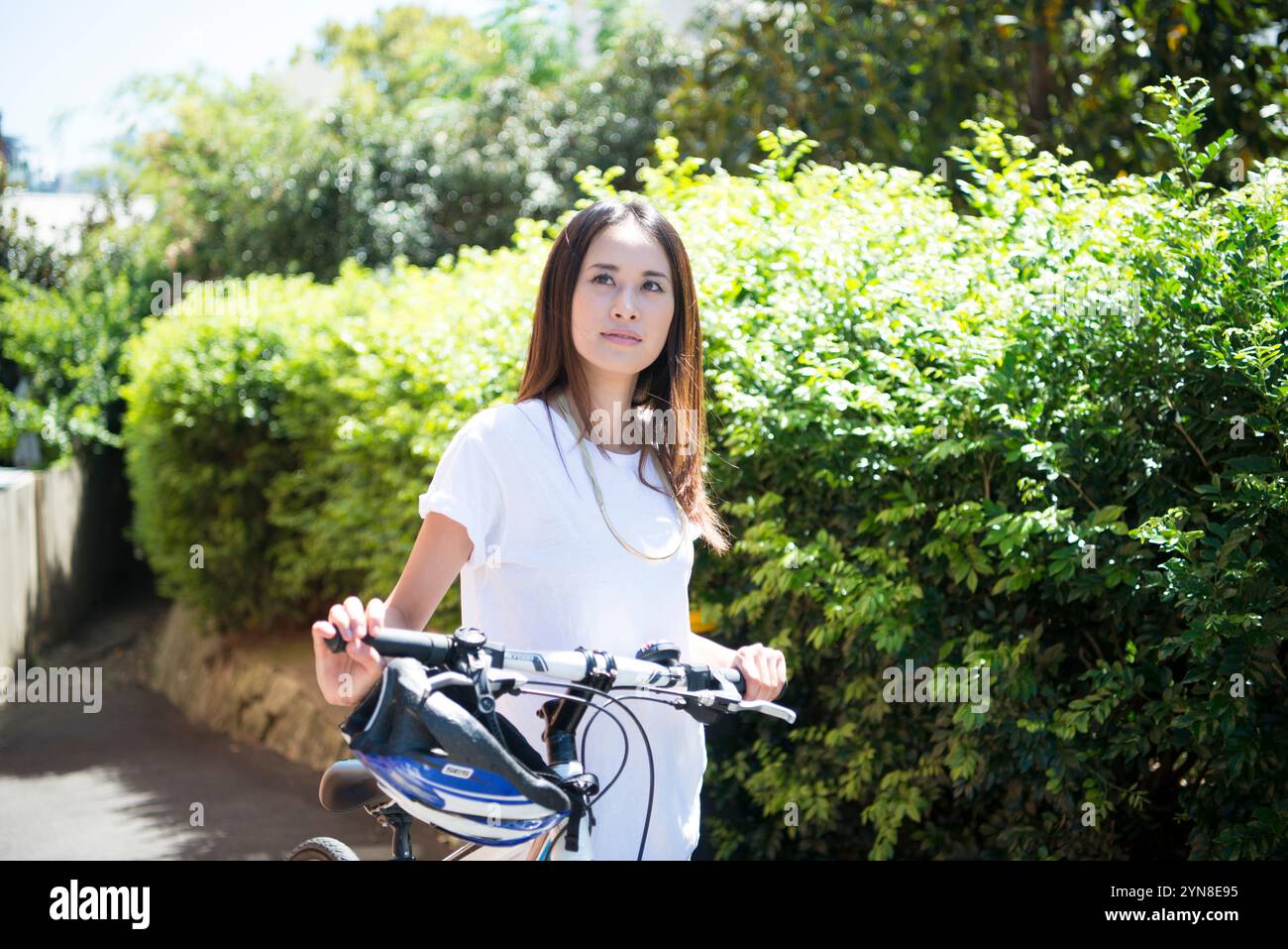 Woman pulling a bicycle Stock Photo - Alamy