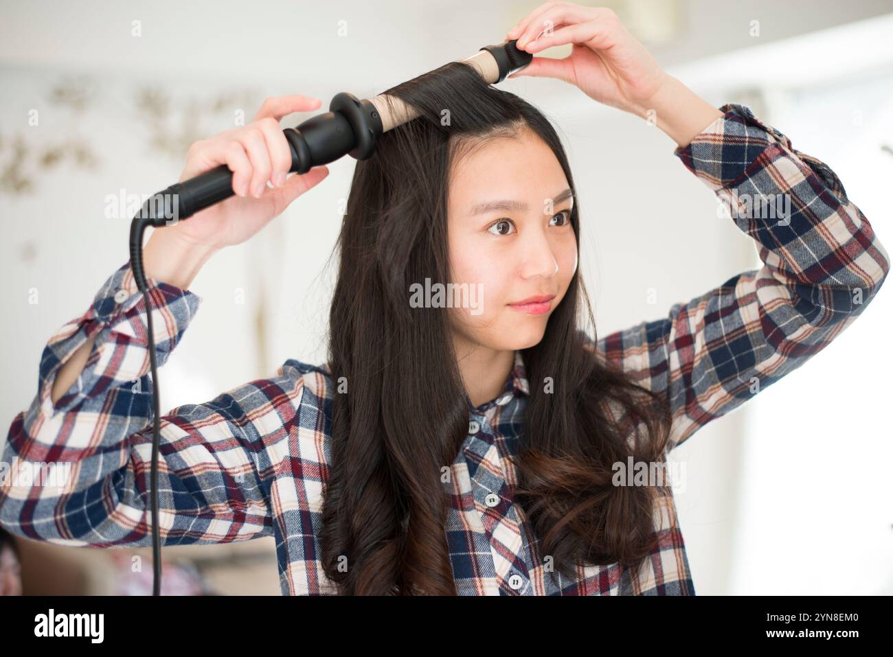 Woman curling hair Stock Photo - Alamy