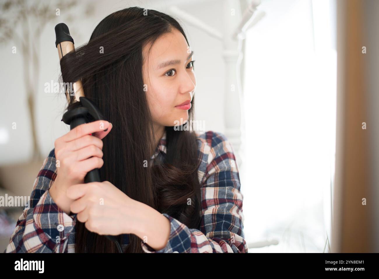Woman curling hair Stock Photo - Alamy