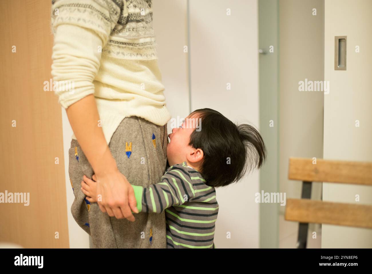 Boy clinging to mother and crying Stock Photo - Alamy