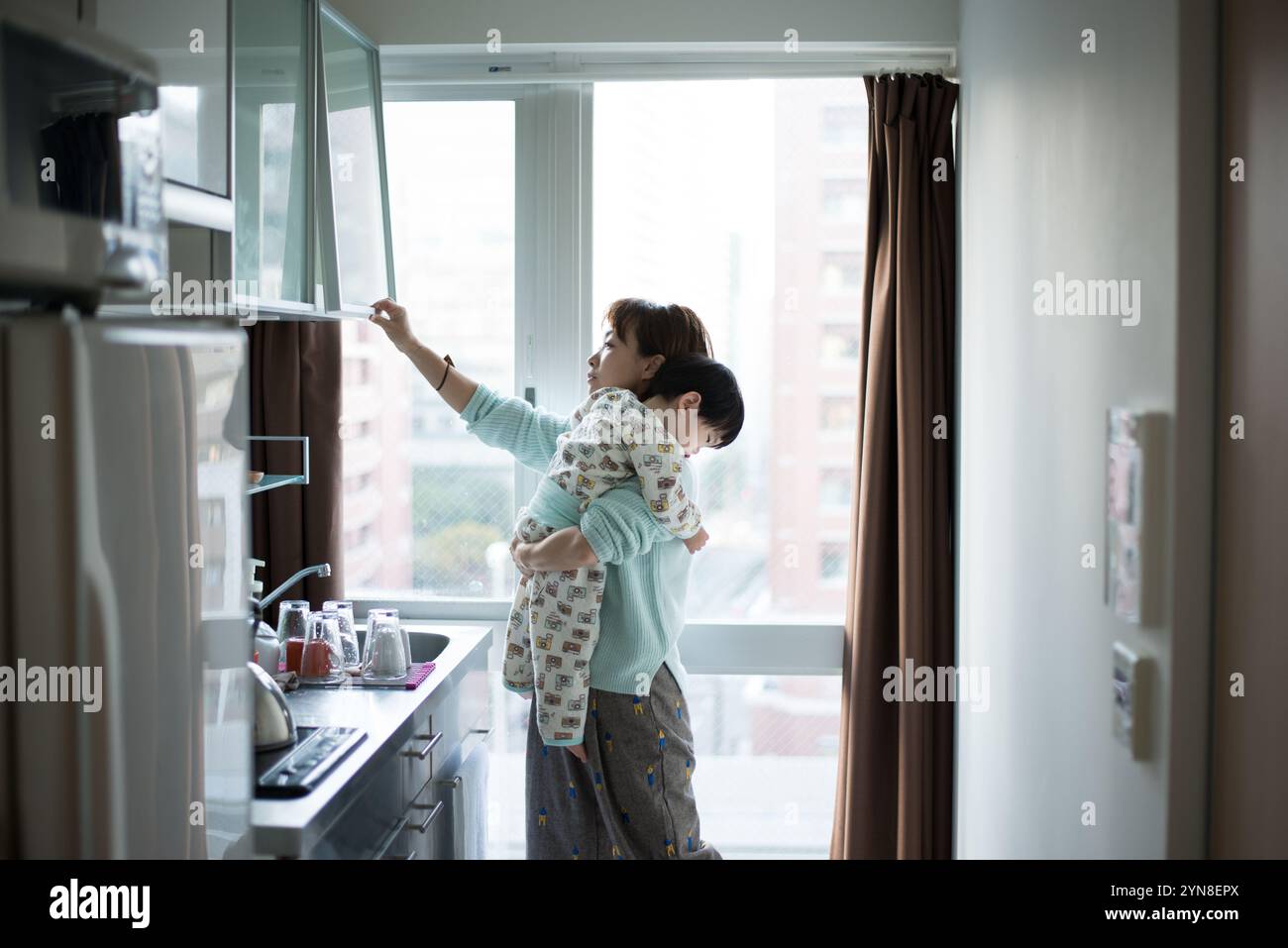 Boy being carried by his mother Stock Photo - Alamy