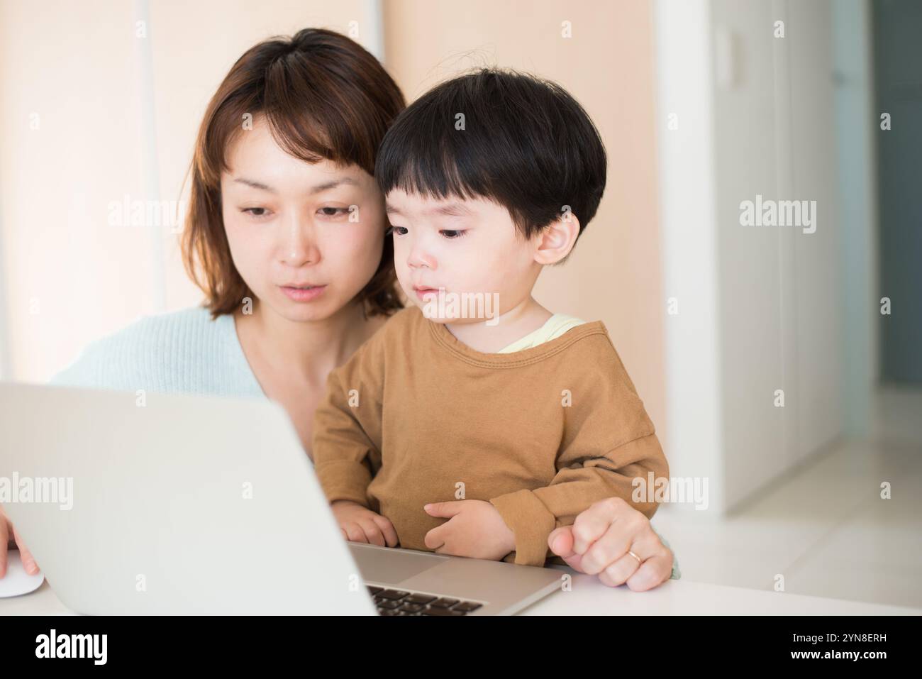 Parent and child looking at computer Stock Photo - Alamy
